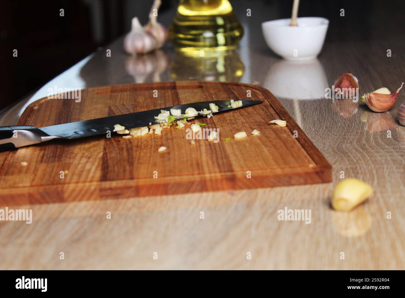 Chopped chopped garlic on a cutting board next to a knife. Making a ...