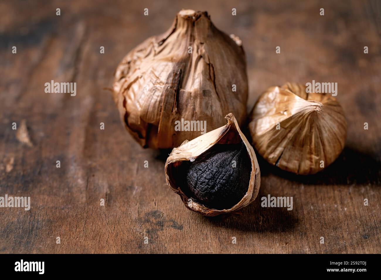 Black fermented garlic whole and peeled garlic clove on dark wooden ...