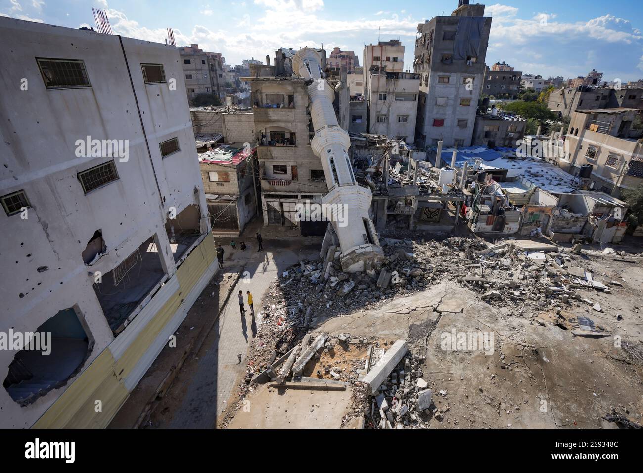 Palestinians walk past a mosque destroyed by the Israeli airstrikes in ...