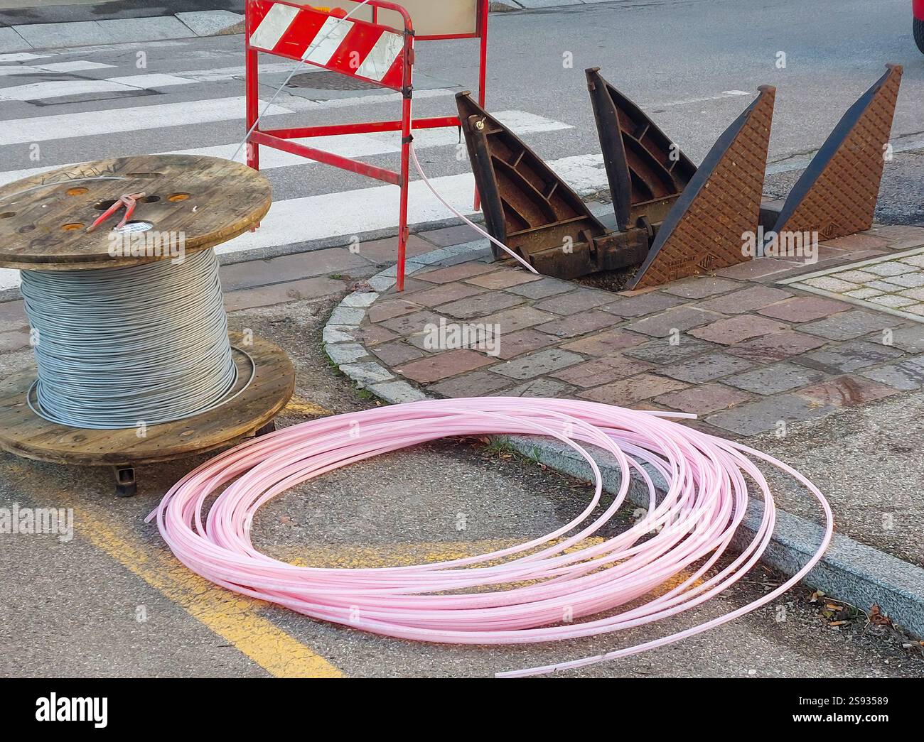 Pink fiber optic cable lying on the ground during maintenance near an ...
