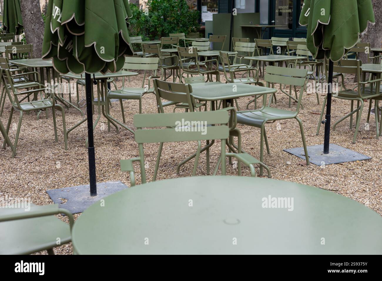 Outdoor seating area with green umbrellas and tables in a park during ...