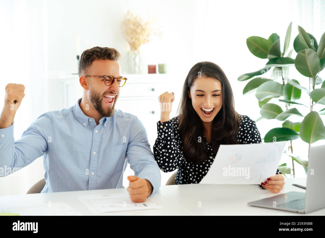 Joyful professional business partners celebrating success at the office ...