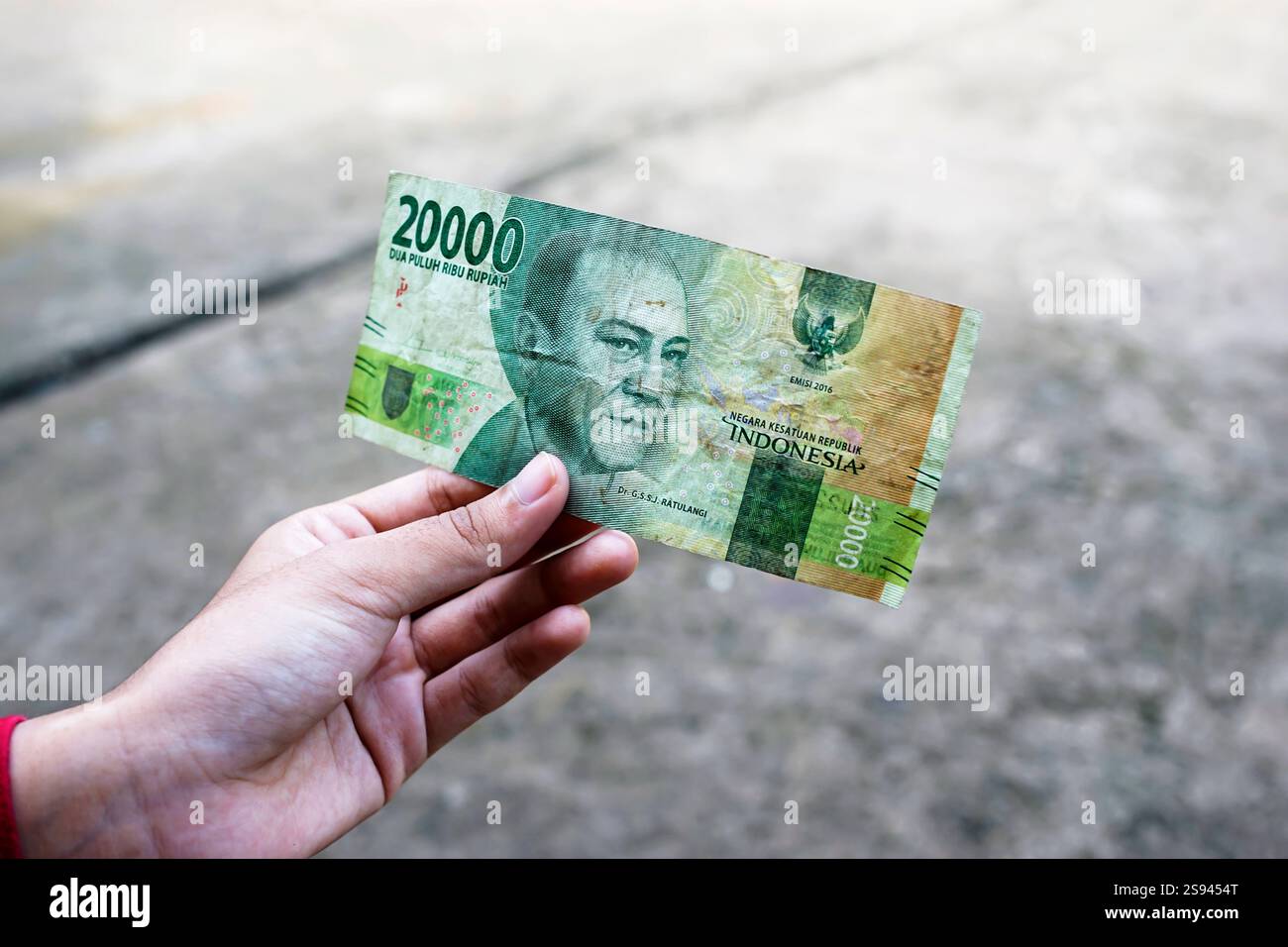 woman shows money twenty thousand rupiahs Stock Photo - Alamy