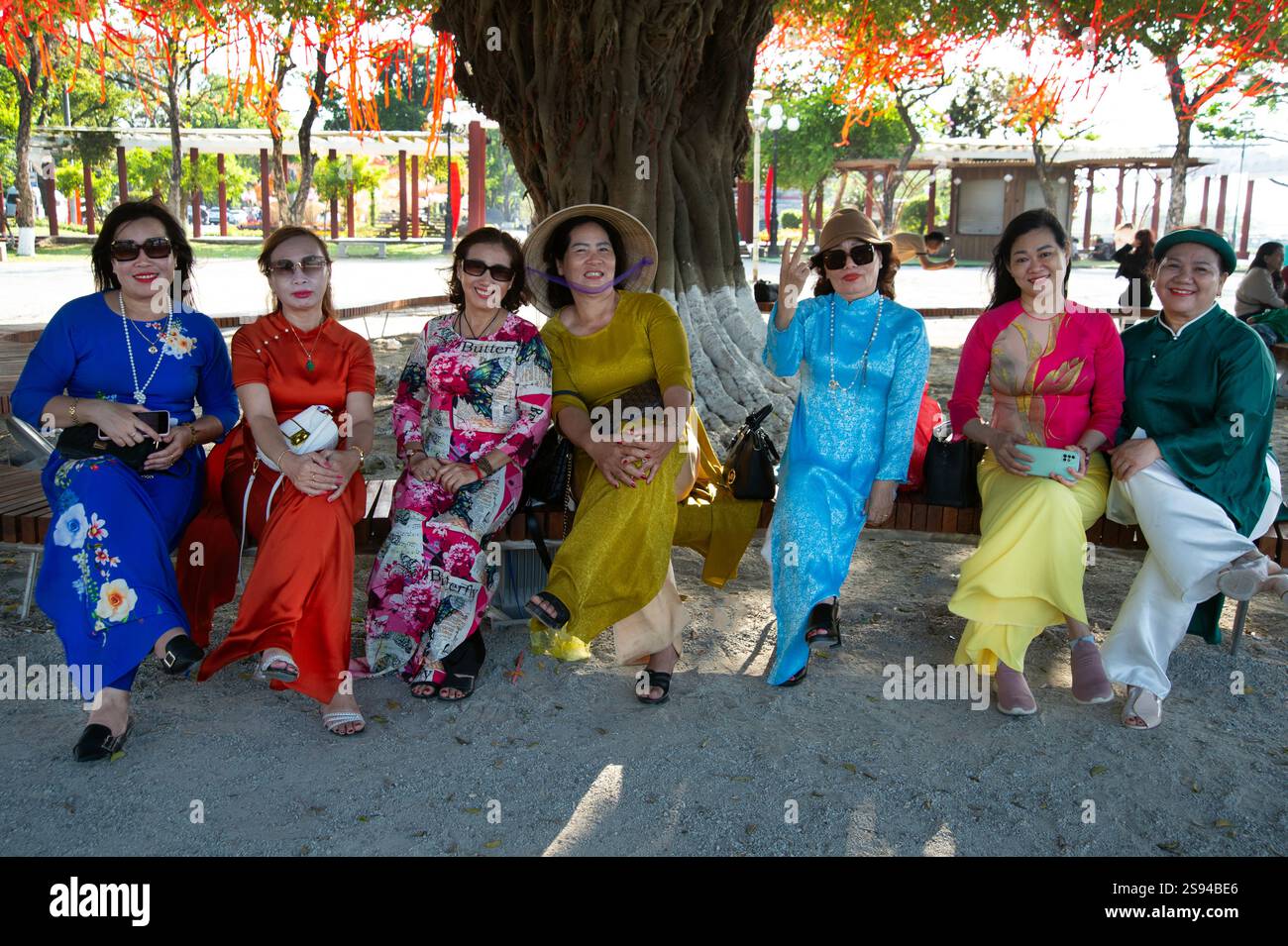 Group of smiling seven Vietnamese ladies dressed in traditional Ao dai ...