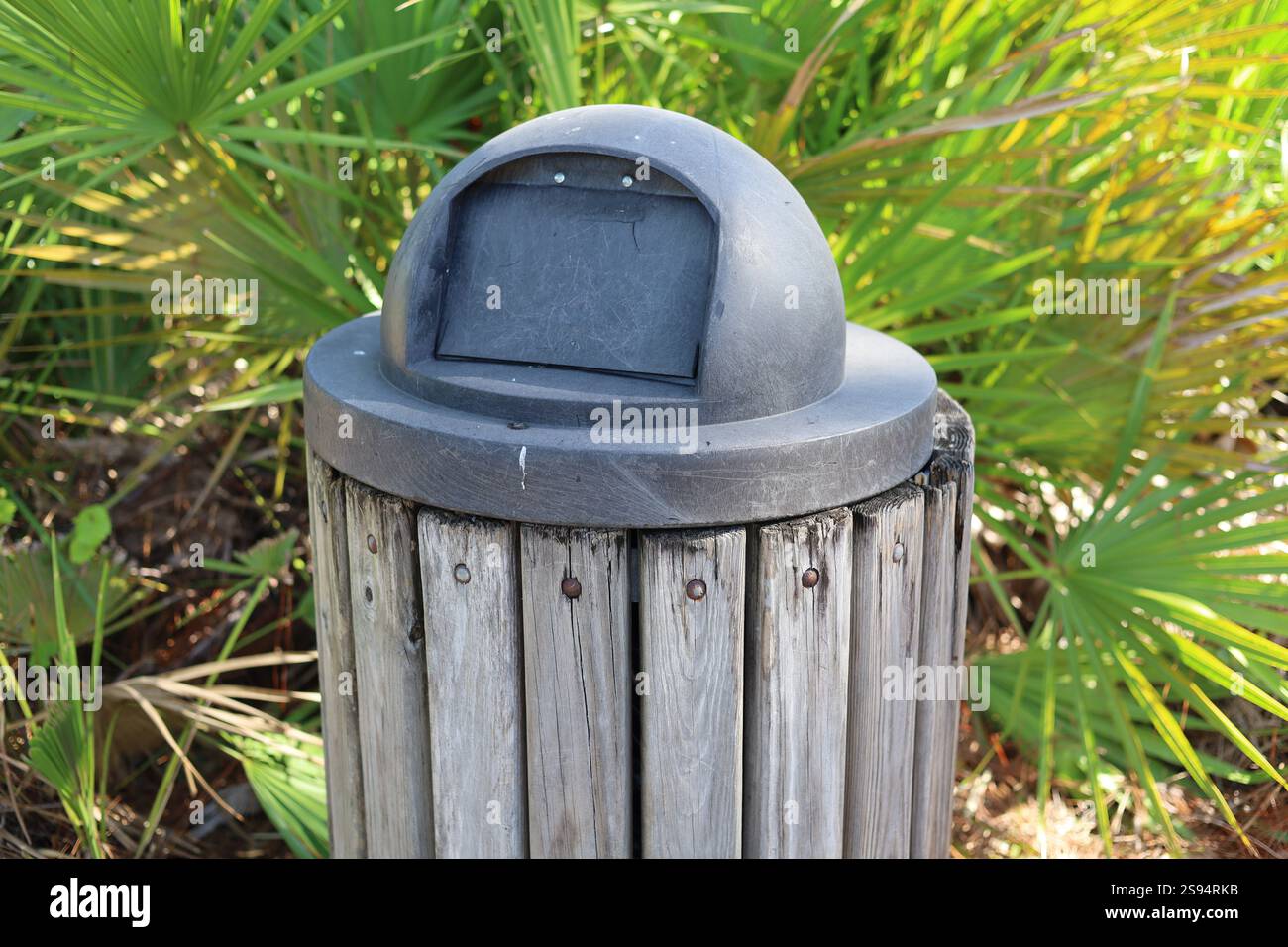 Garbage can with wood trim in tropical park Stock Photo - Alamy