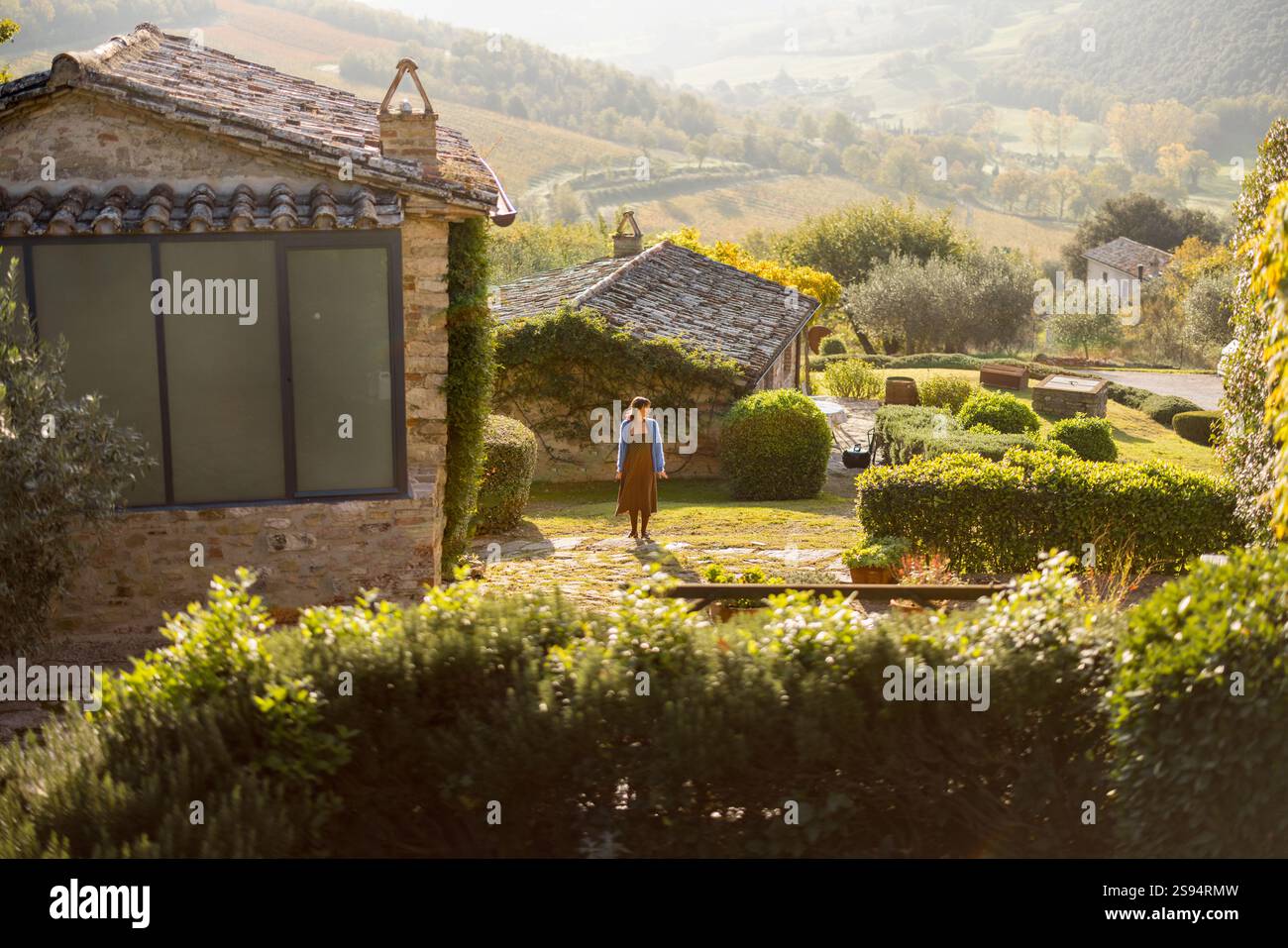A picturesque view of a woman walking through a quaint countryside ...