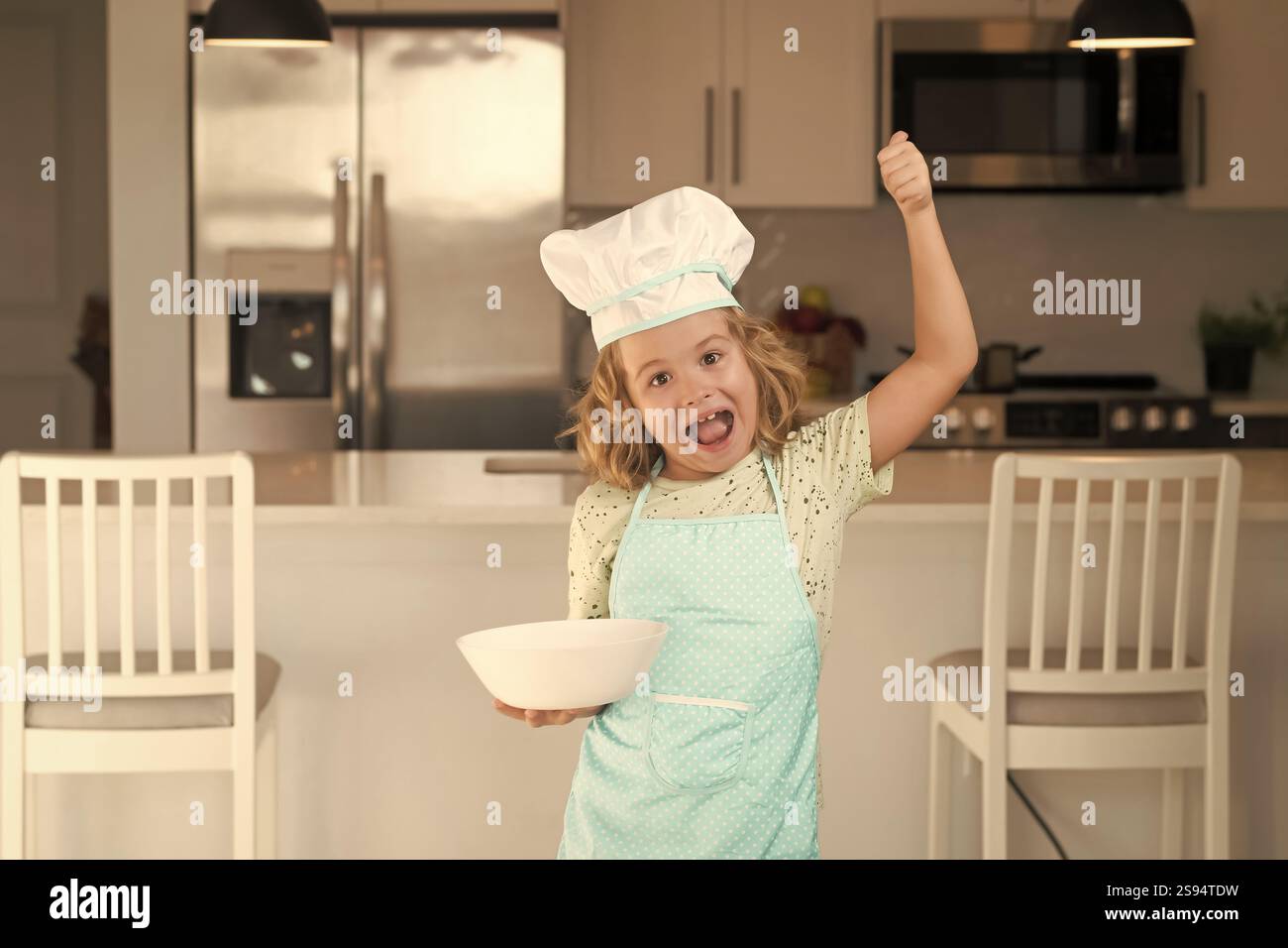 Child chef cook with cooking plate. Child chef cook prepares food at ...