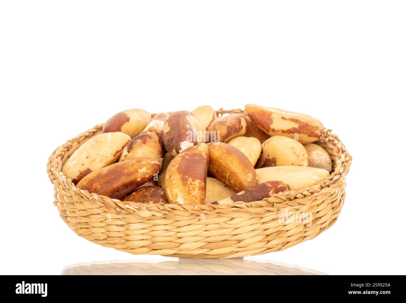 Brazil nuts without shells with straw plate, macro, isolated on white ...