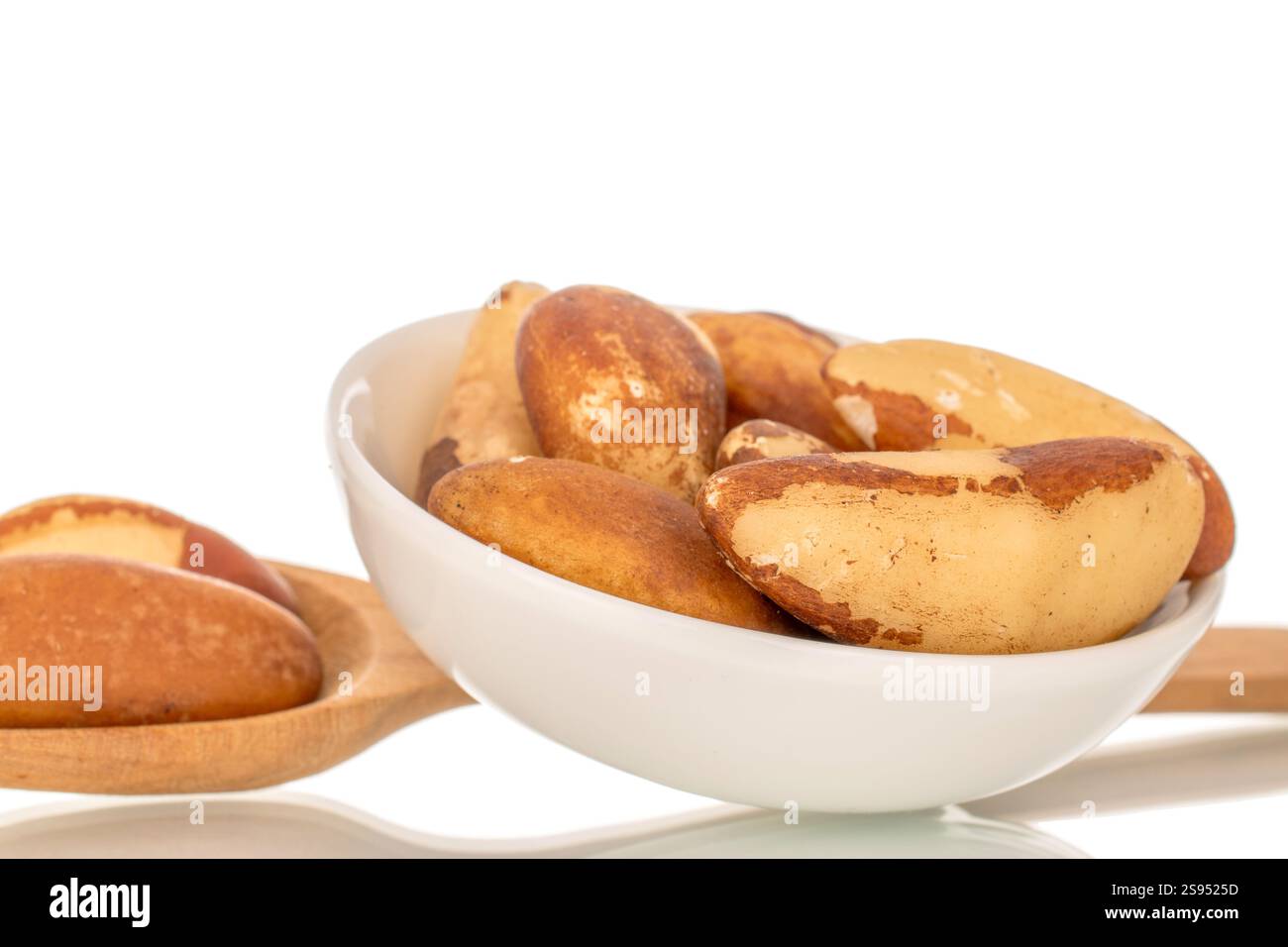 Brazil nuts without shells with ceramic saucer and wooden spoon, macro ...