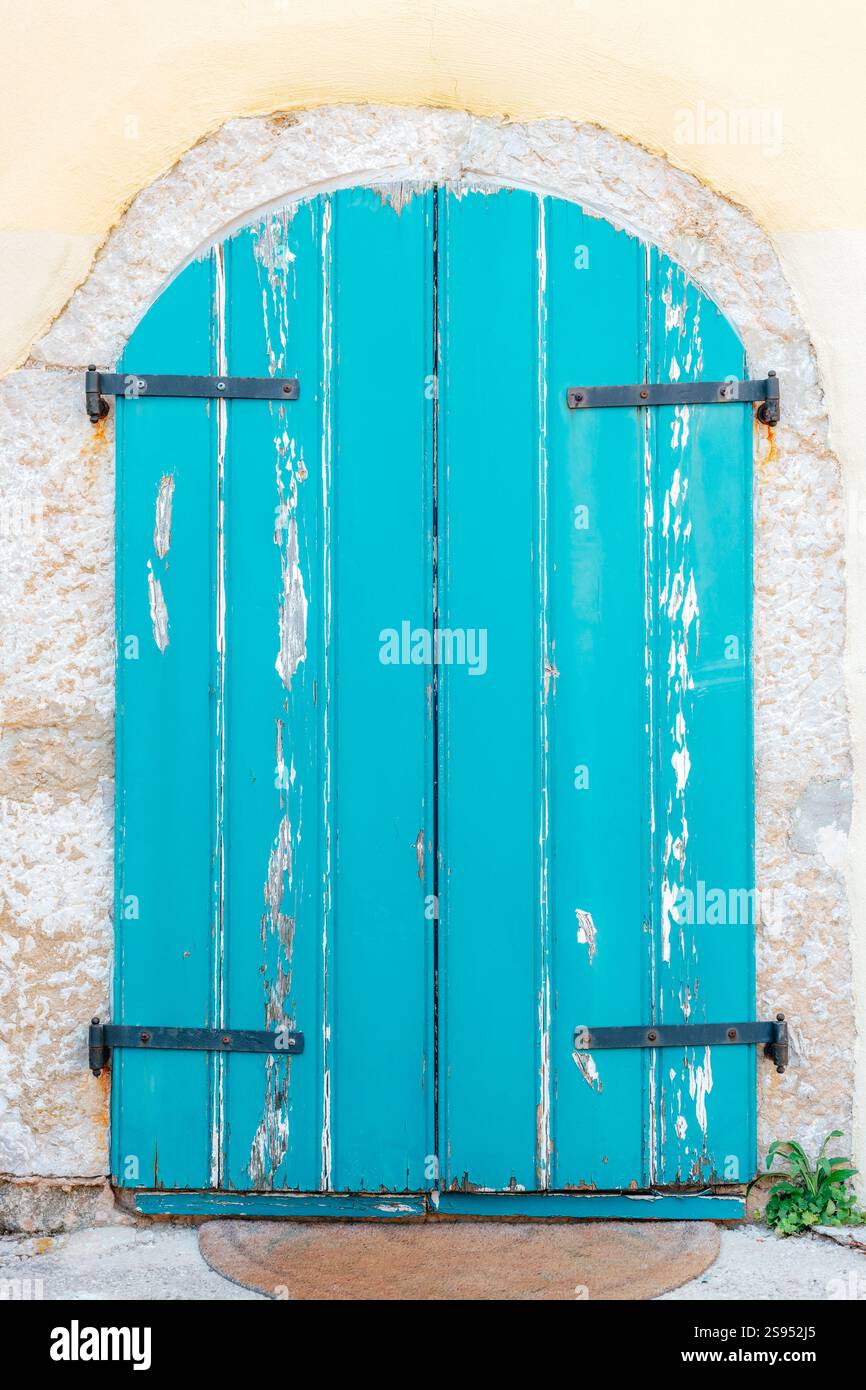 Old turquoise wooden door with peeling paint and stone frame ...