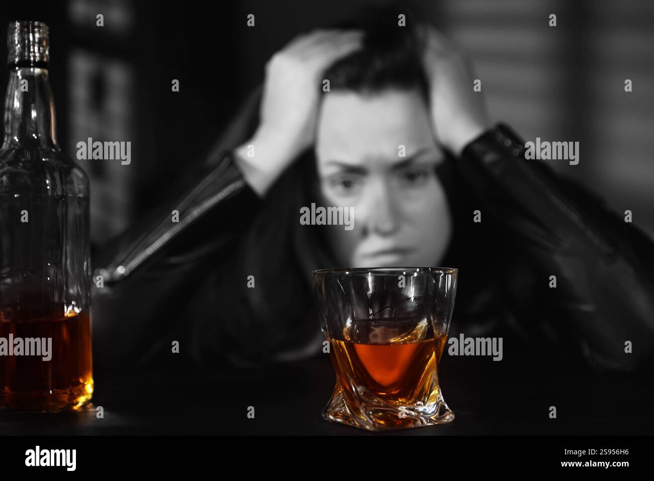 Alcohol addiction. Depressed woman at table, focus on glass of whiskey Stock Photo - Alamy