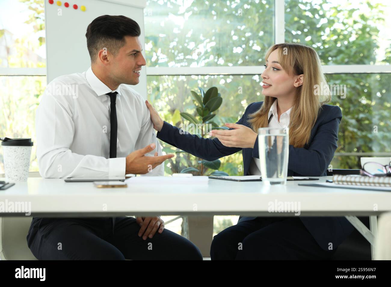Office employees talking at table during meeting Stock Photo - Alamy