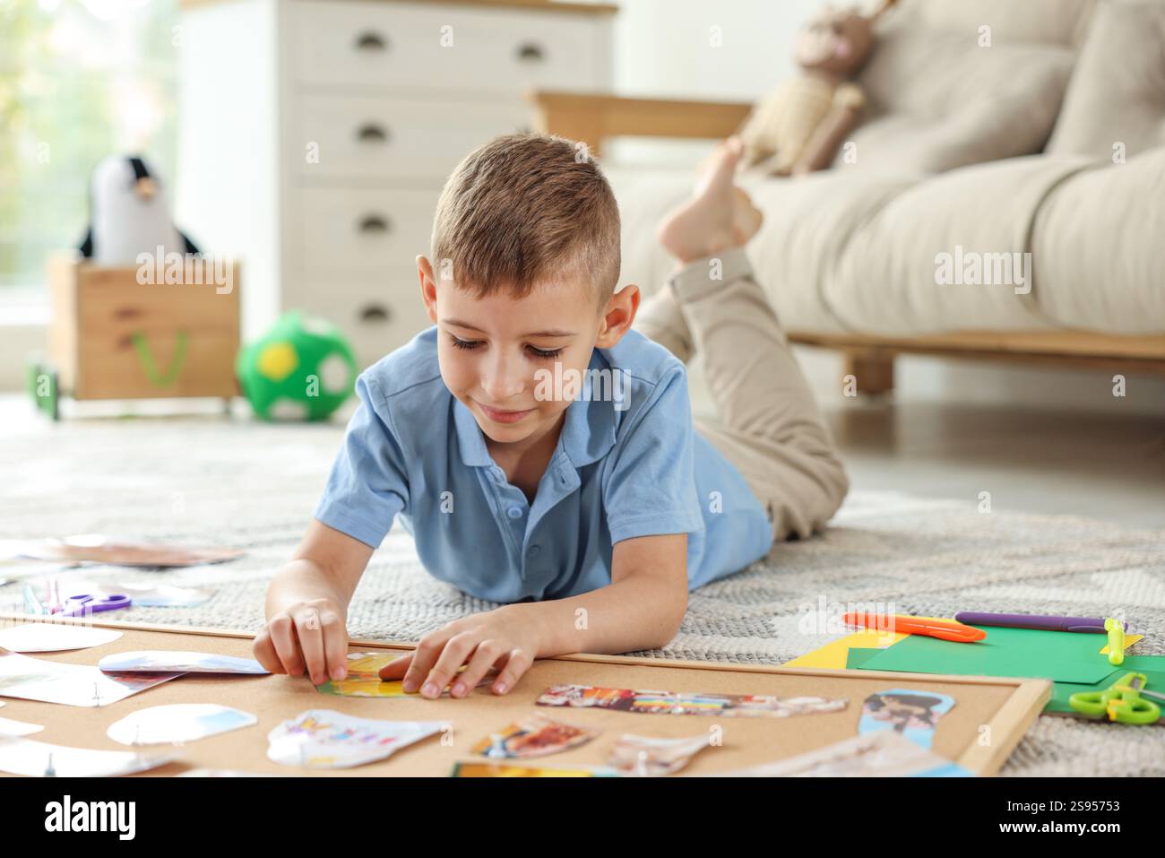 Little boy creating vision board with different pictures and other ...