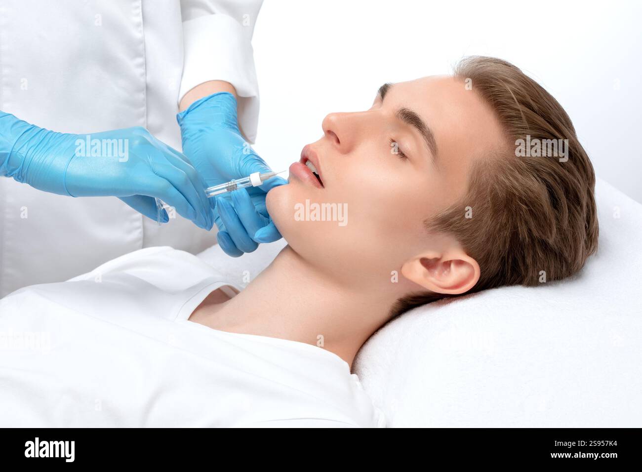 The cosmetologist makes injections for lip augmentation and anti ...