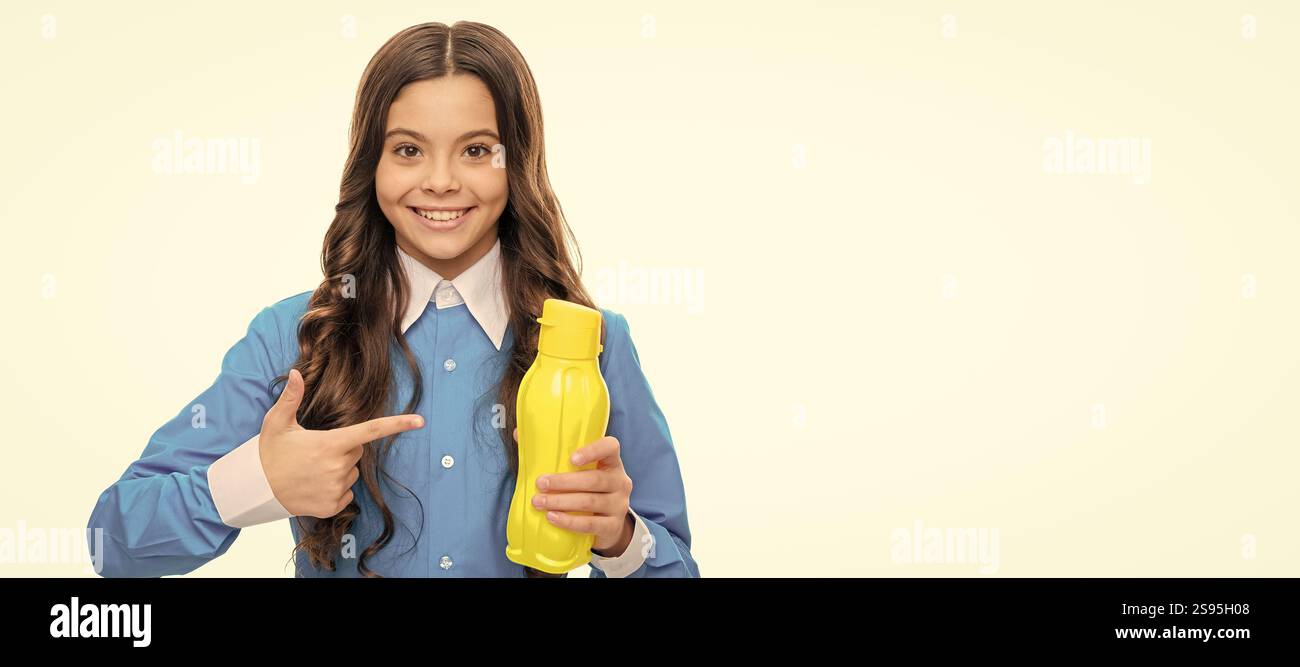 Happy kid point index finger at yellow plastic liquid drinking bottle ...
