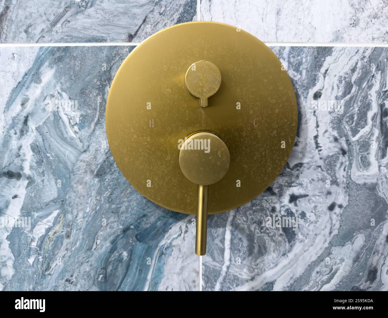 Elegant brass water fixture embedded in luxurious marbled wall design ...