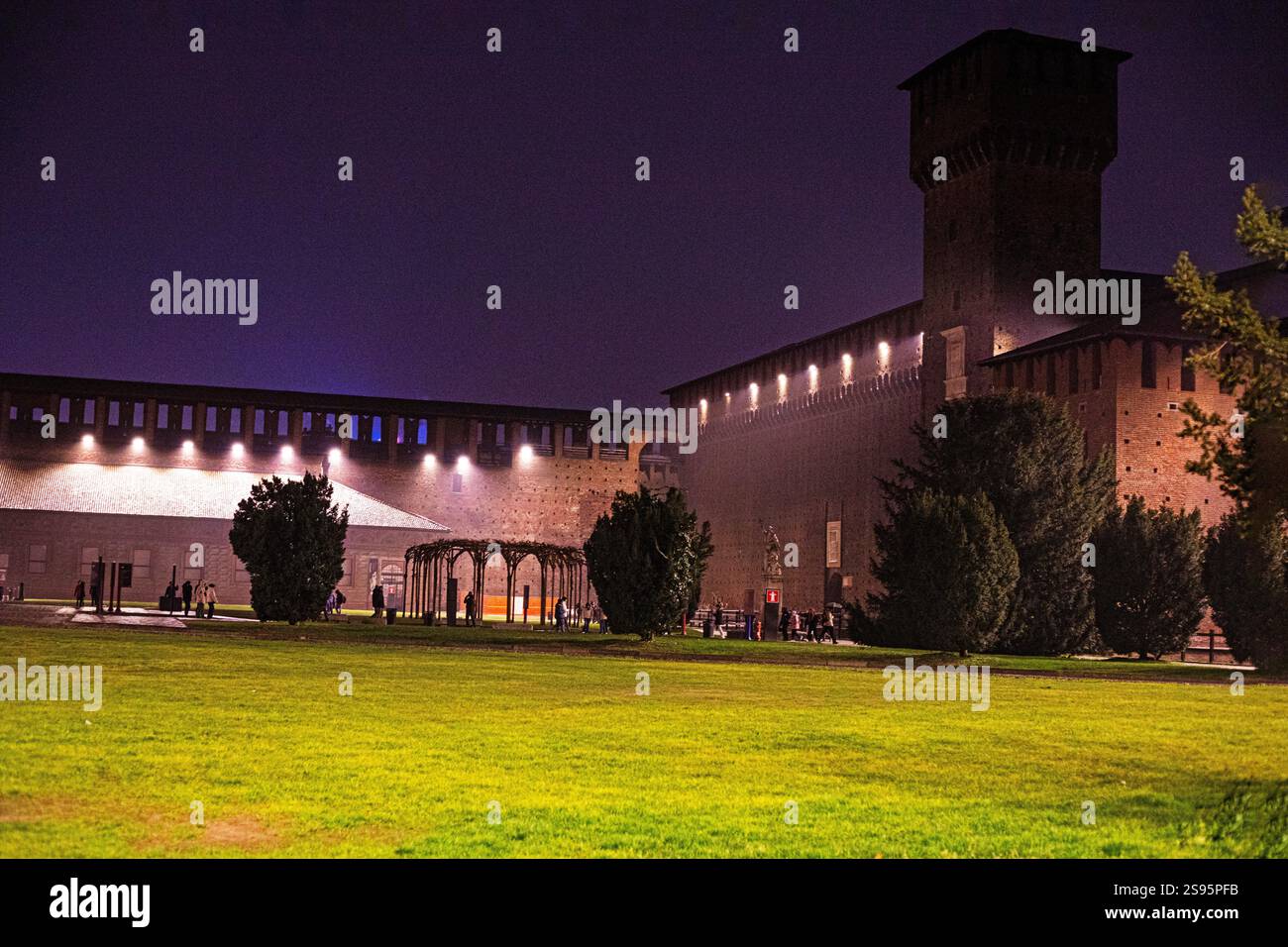 ancient Gothic castle illuminated in the evening through the branches ...