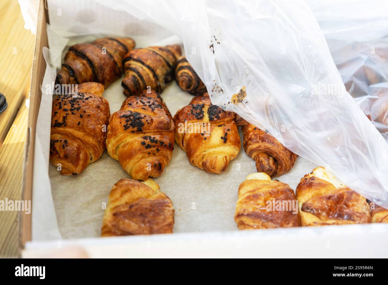 Freshly baked puff croissants with cinnamon and poppy seeds packed in a ...