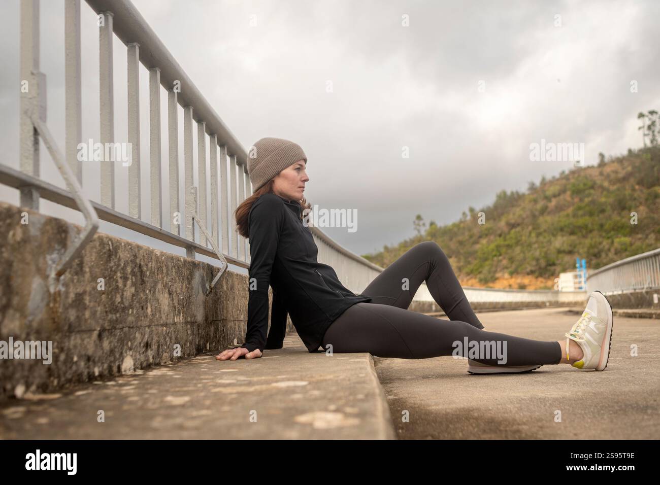woman runner sitting on the road exhausted after jogging Stock Photo ...