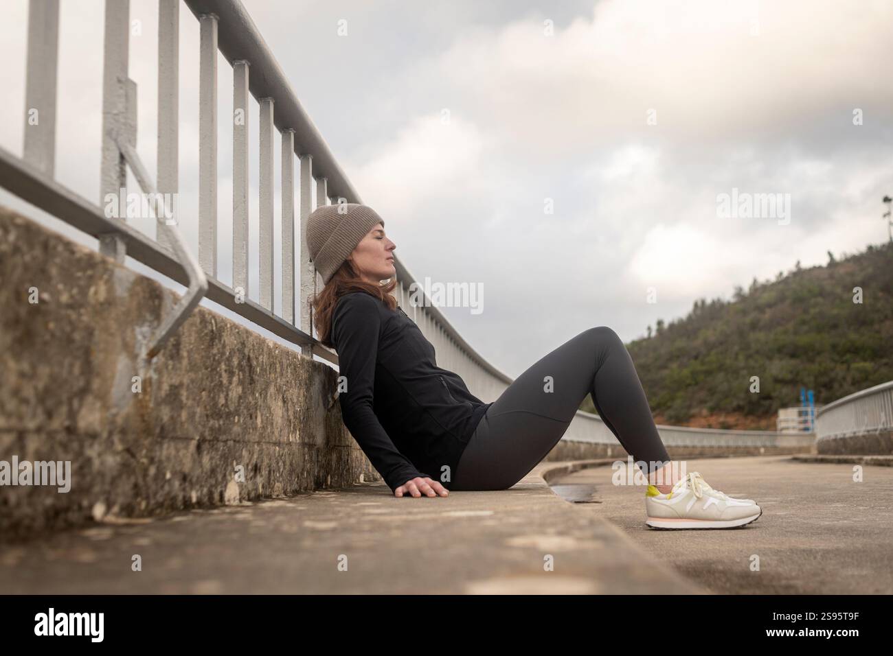 woman runner sitting on the road exhausted after jogging Stock Photo ...