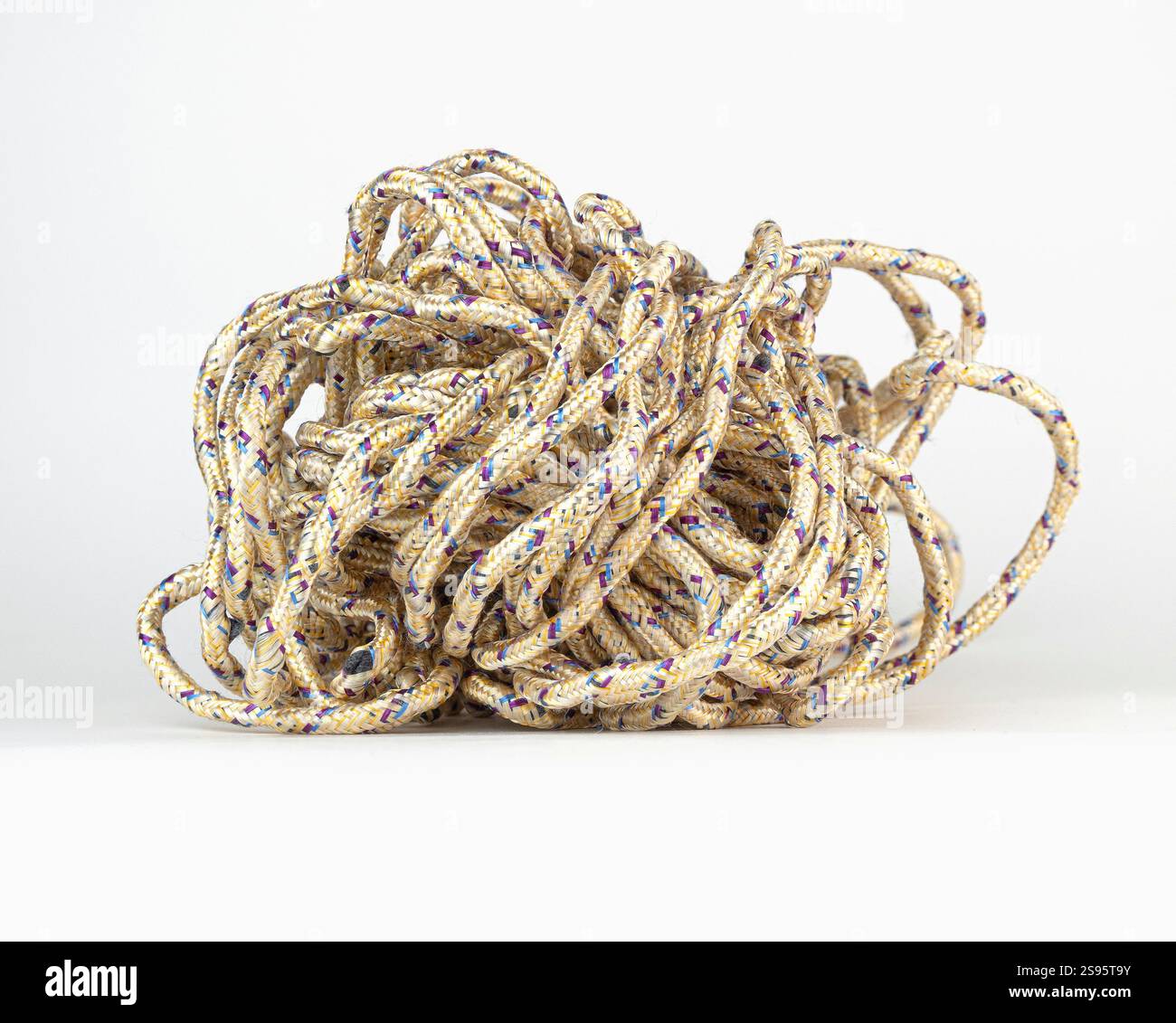 A tangled knot of rope lies on a plain white background with colorful ...