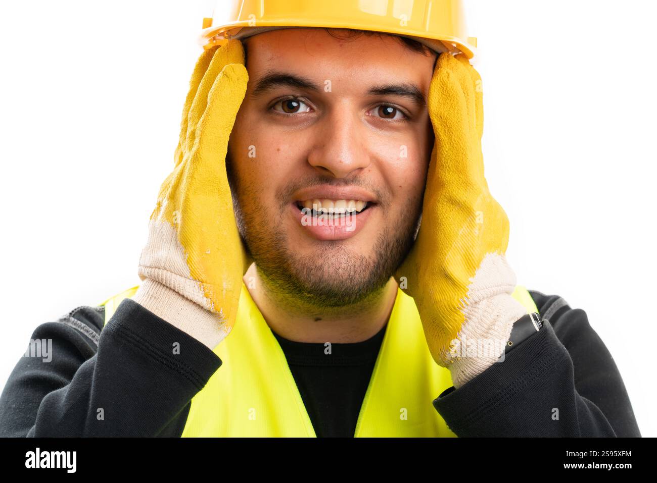 Close-up of male construction worker covering ears with hands wearing ...