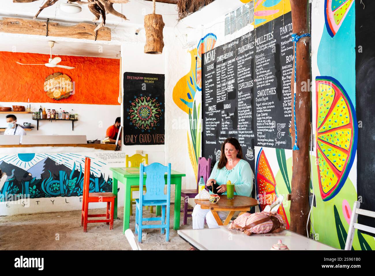 Woman buys a green juice smoothie at an outdoor juice bar in Holbox ...