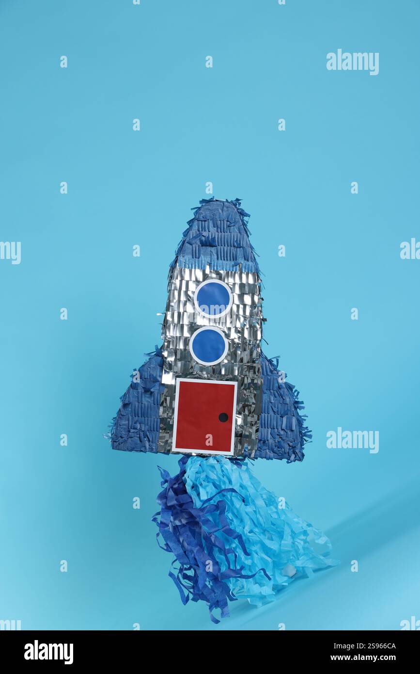 Rocket shaped pinata on light blue background Stock Photo - Alamy