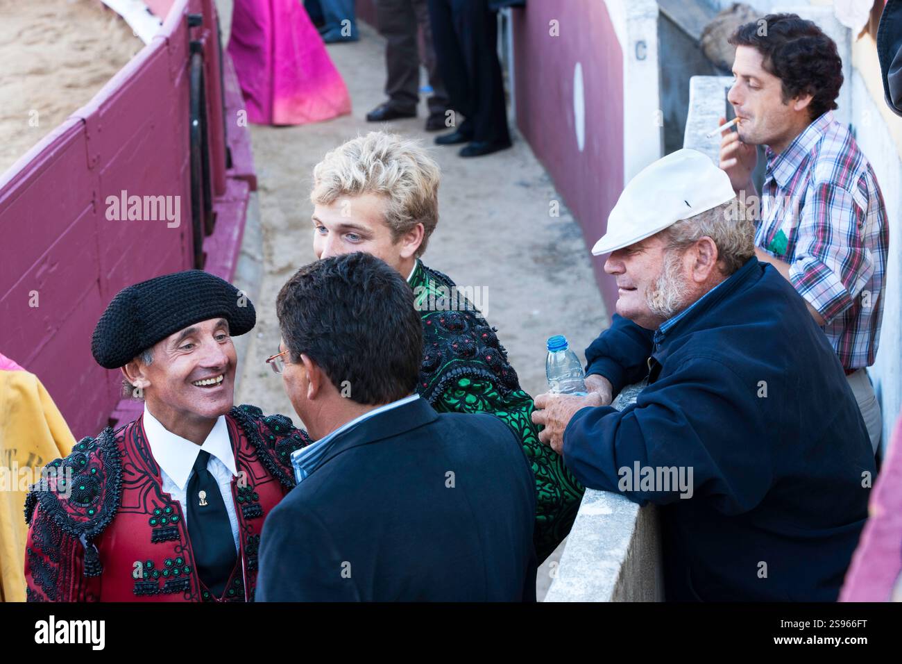 Costumed matador and forcado men talk with local men during the ...