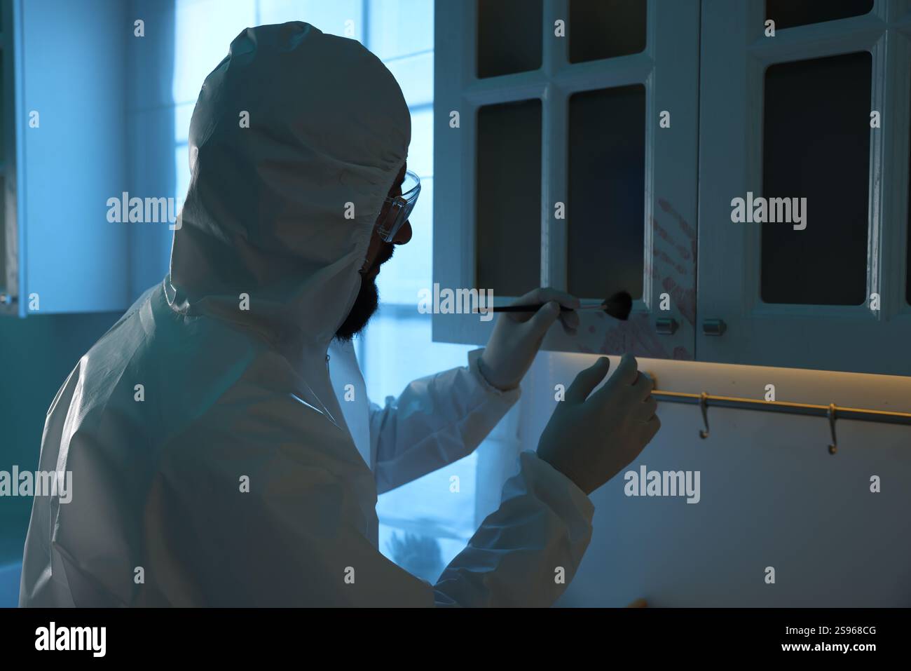 Forensic expert taking fingerprints from cupboard with brush at crime ...