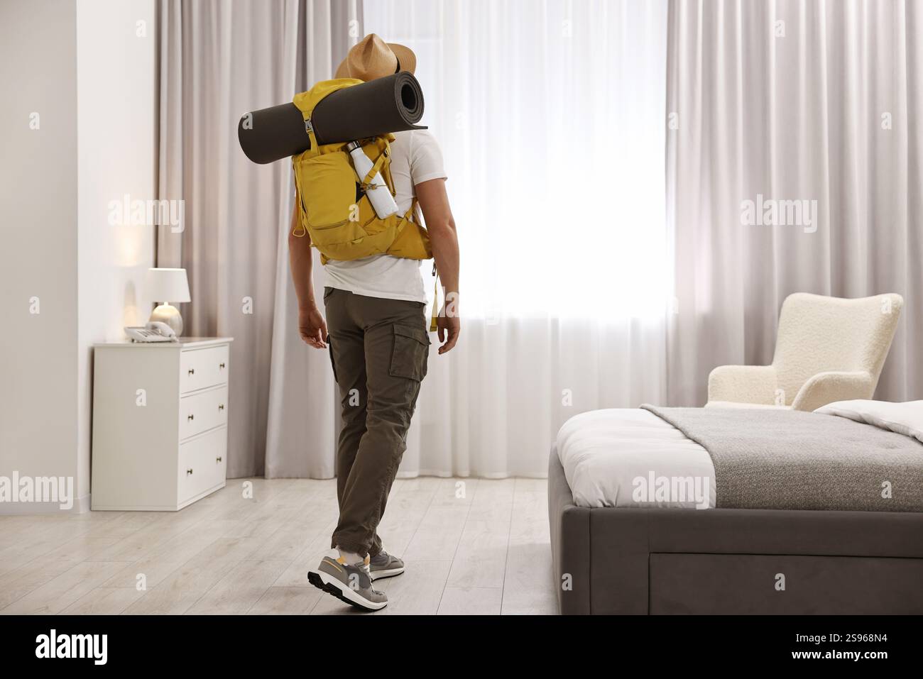 Traveller with backpack in hotel room, back view Stock Photo - Alamy