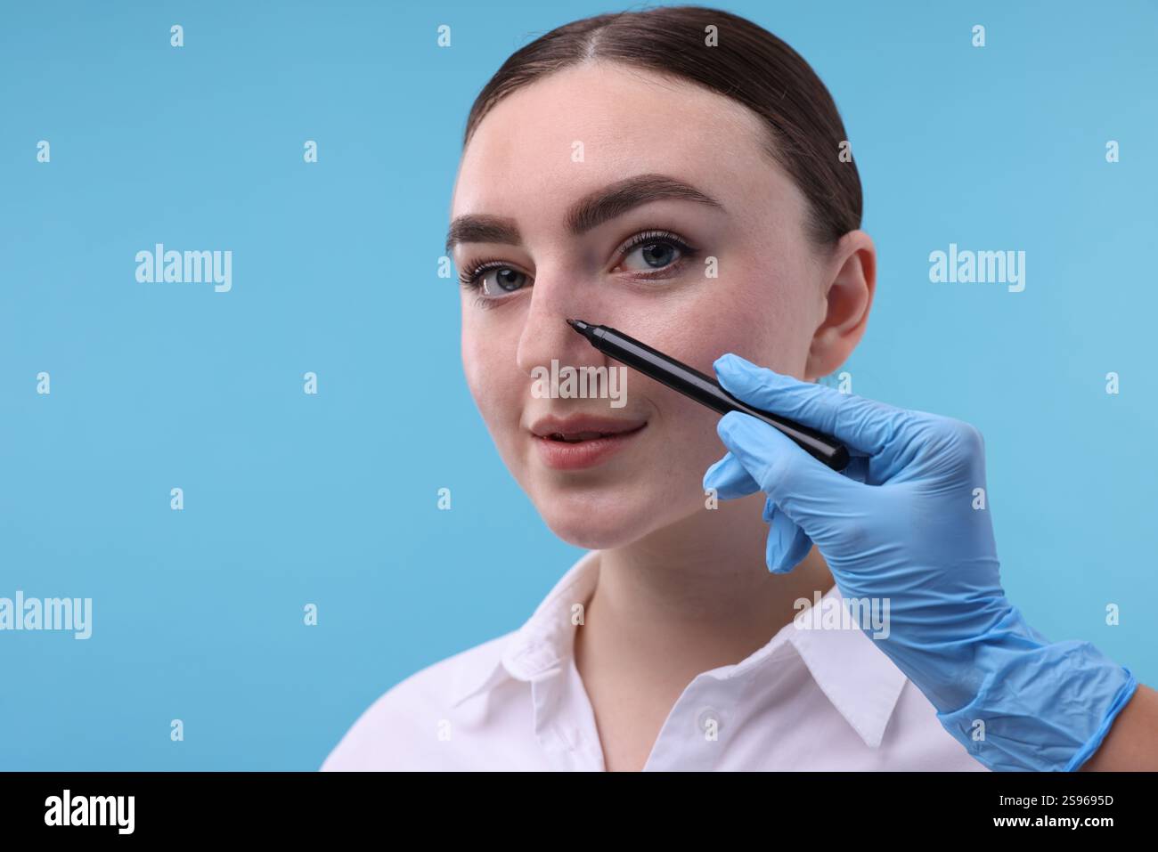 Doctor drawing marks on patient's nose for plastic surgery operation ...