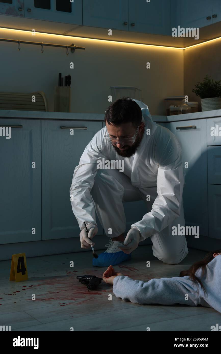 Forensic expert taking fingerprints with brush from gun and dead body ...