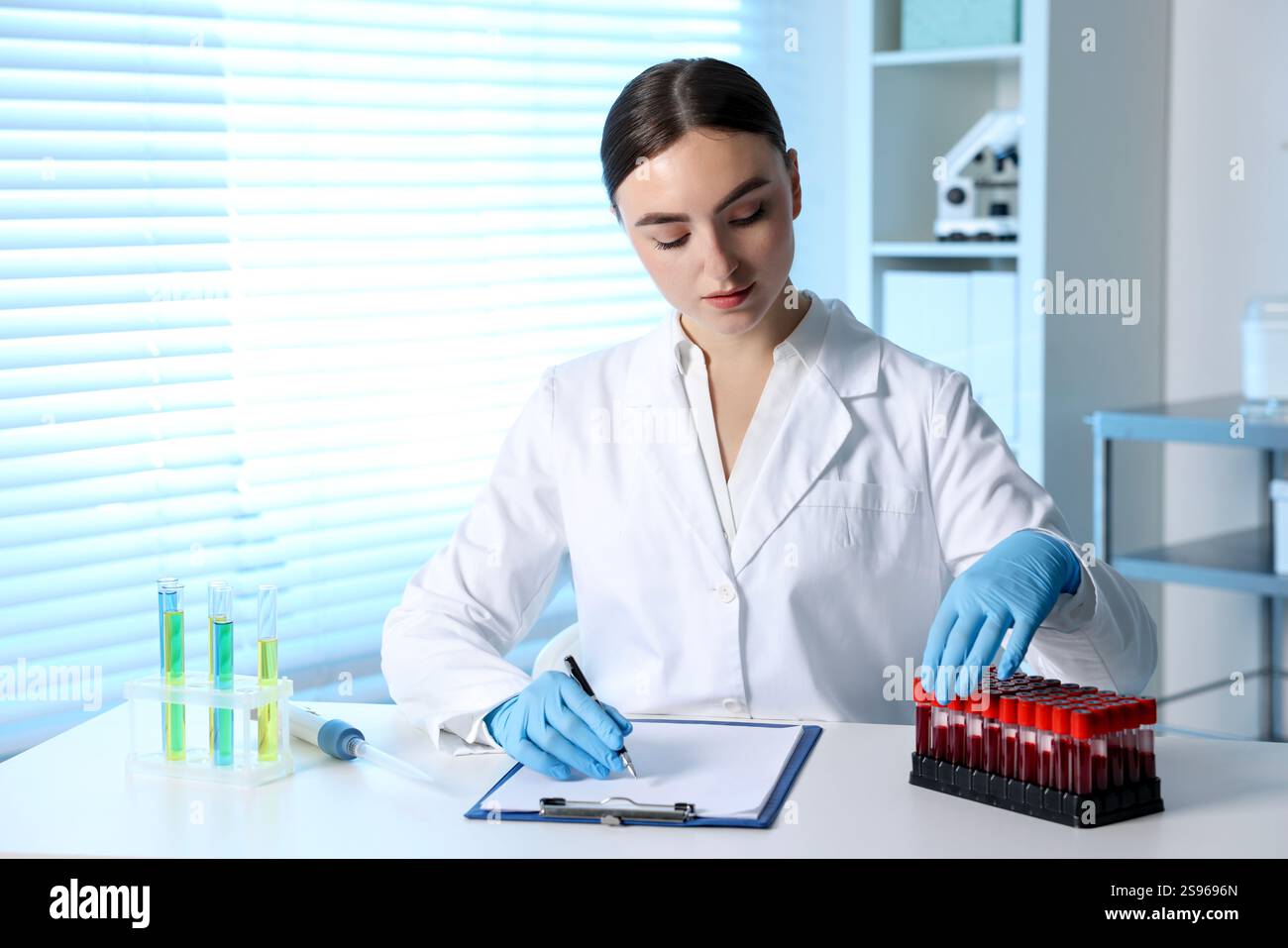 Laboratory testing. Doctor taking test tube with blood sample while ...