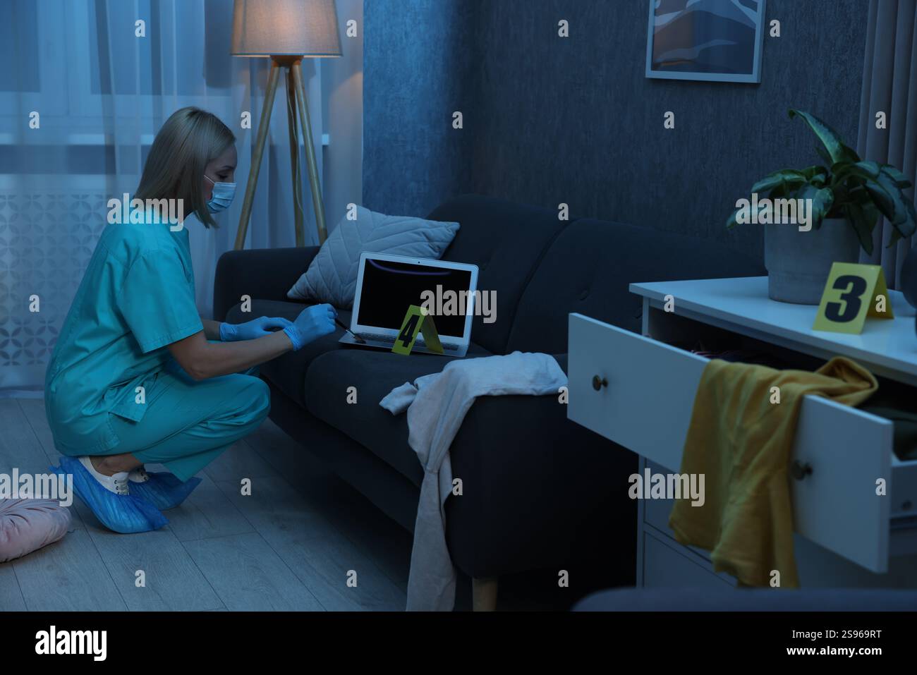 Forensic expert taking fingerprints with brush from laptop at crime ...