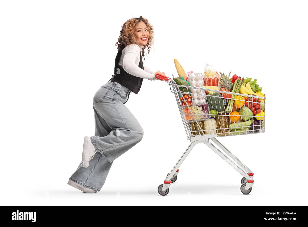 Asian woman running and pushing a shopping cart with groceries isolated ...