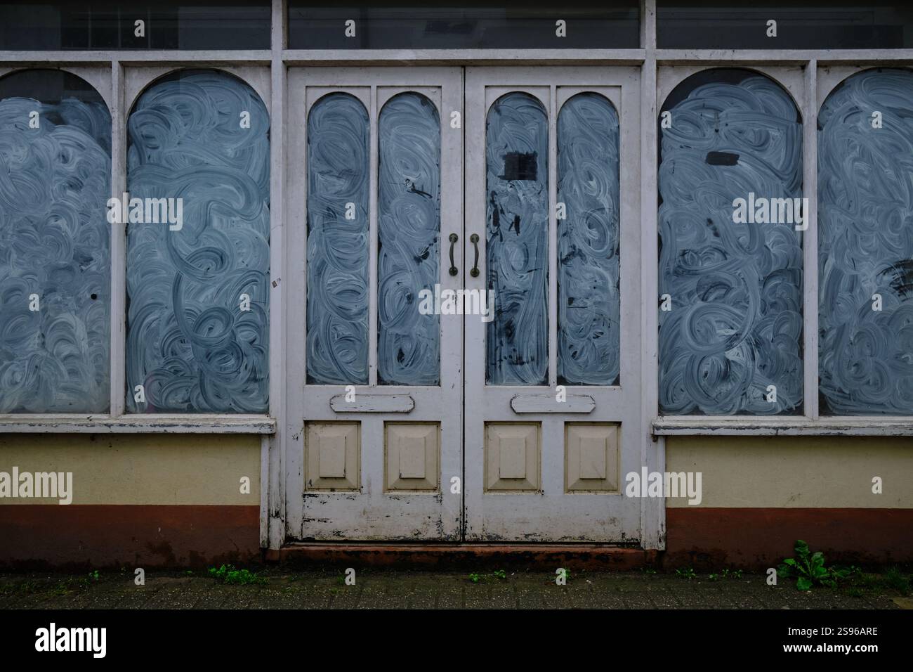 A closed shop for renovation with white washed windows Stock Photo - Alamy