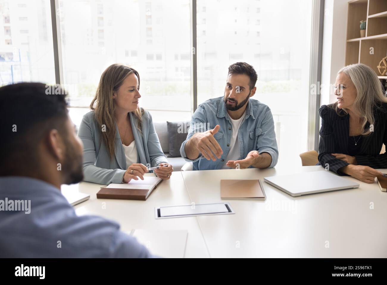 Multiethnic teammates listening speech of skilled Hispanic colleague ...
