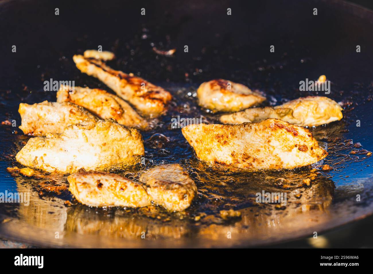 Grilled meat slices browning in hot oil on a plate outdoors Stock Photo ...