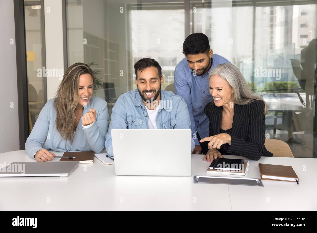Happy workmates using laptop in conference room Stock Photo - Alamy