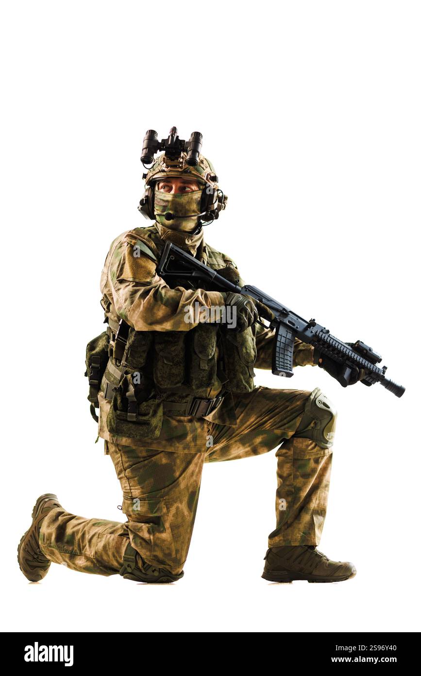 Depicts a soldier in camouflage uniform and equipment, crouching ...