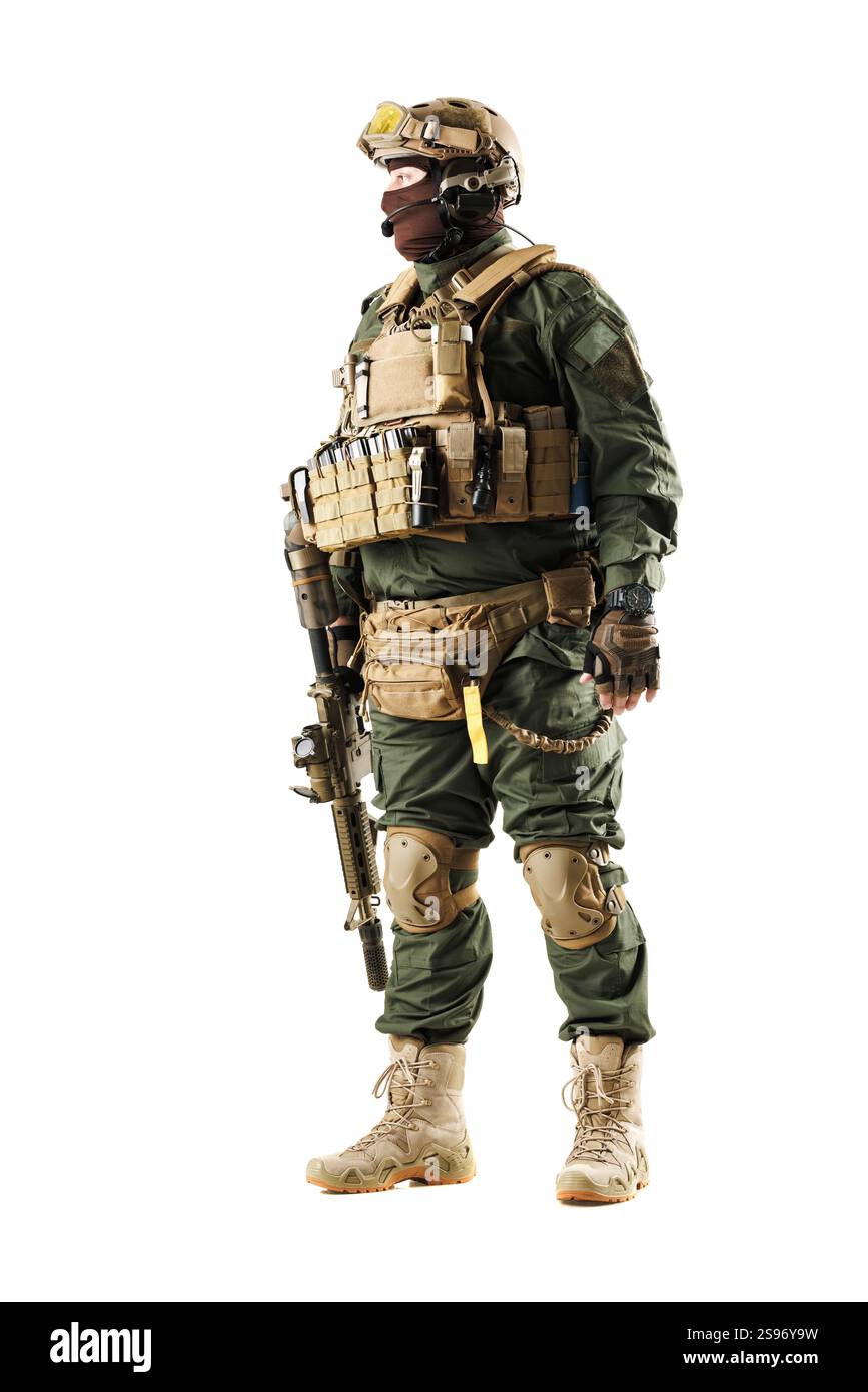 A soldier dressed in advanced tactical military gear holding a rifle ...