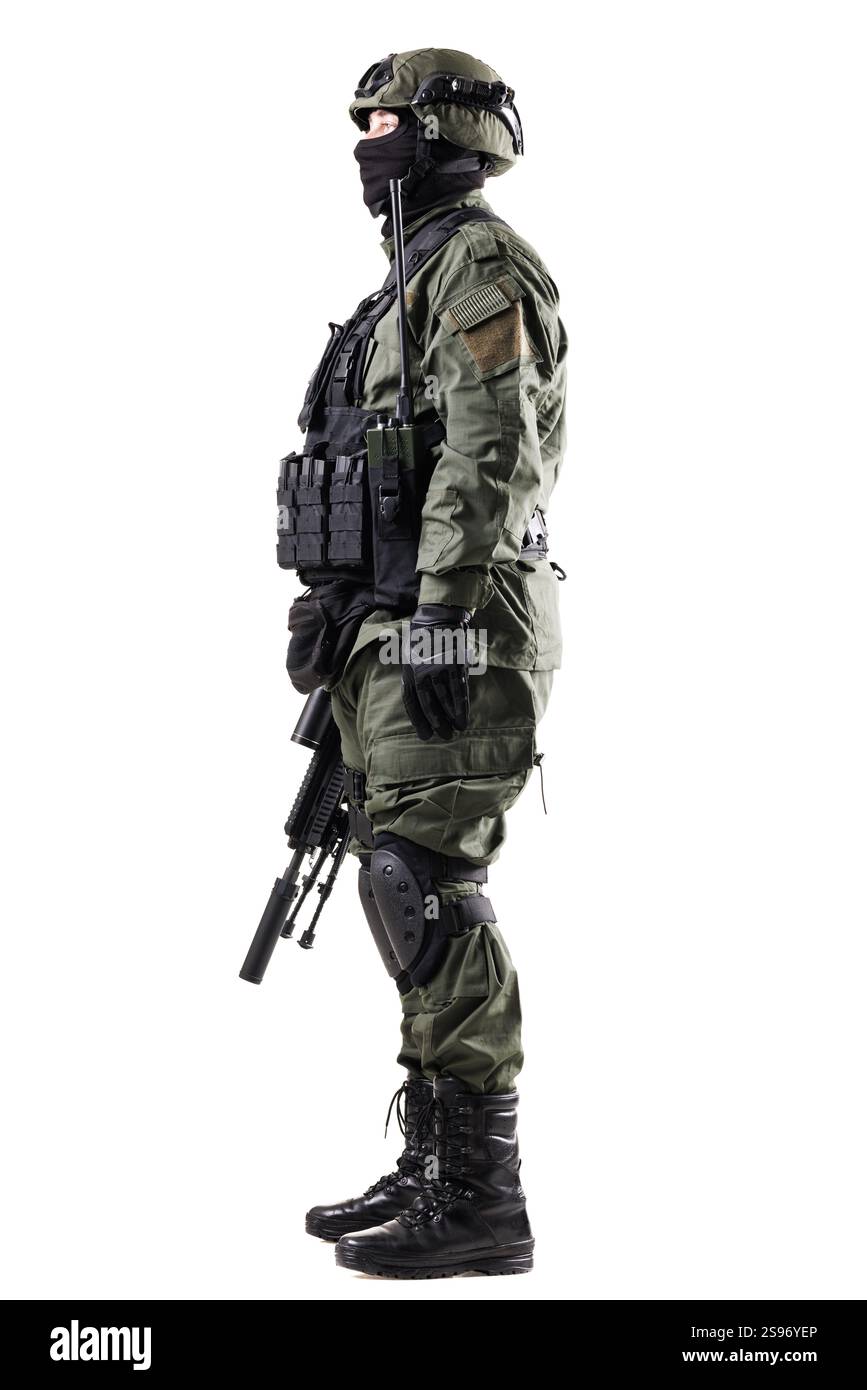 Side view of a tactical soldier dressed in green and black protective ...