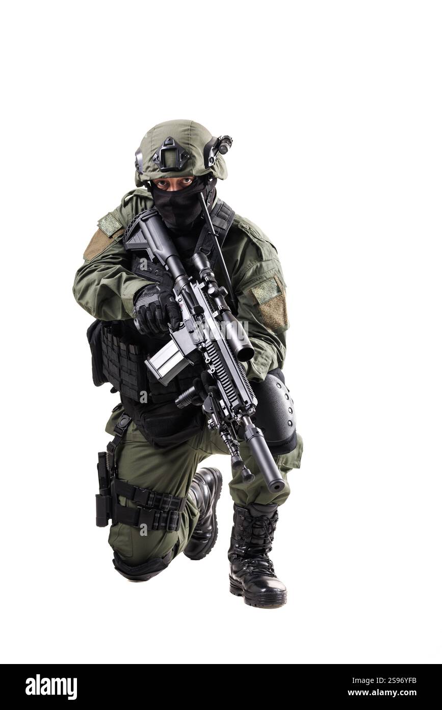 Special forces operative in military gear holding a weapon in a ...