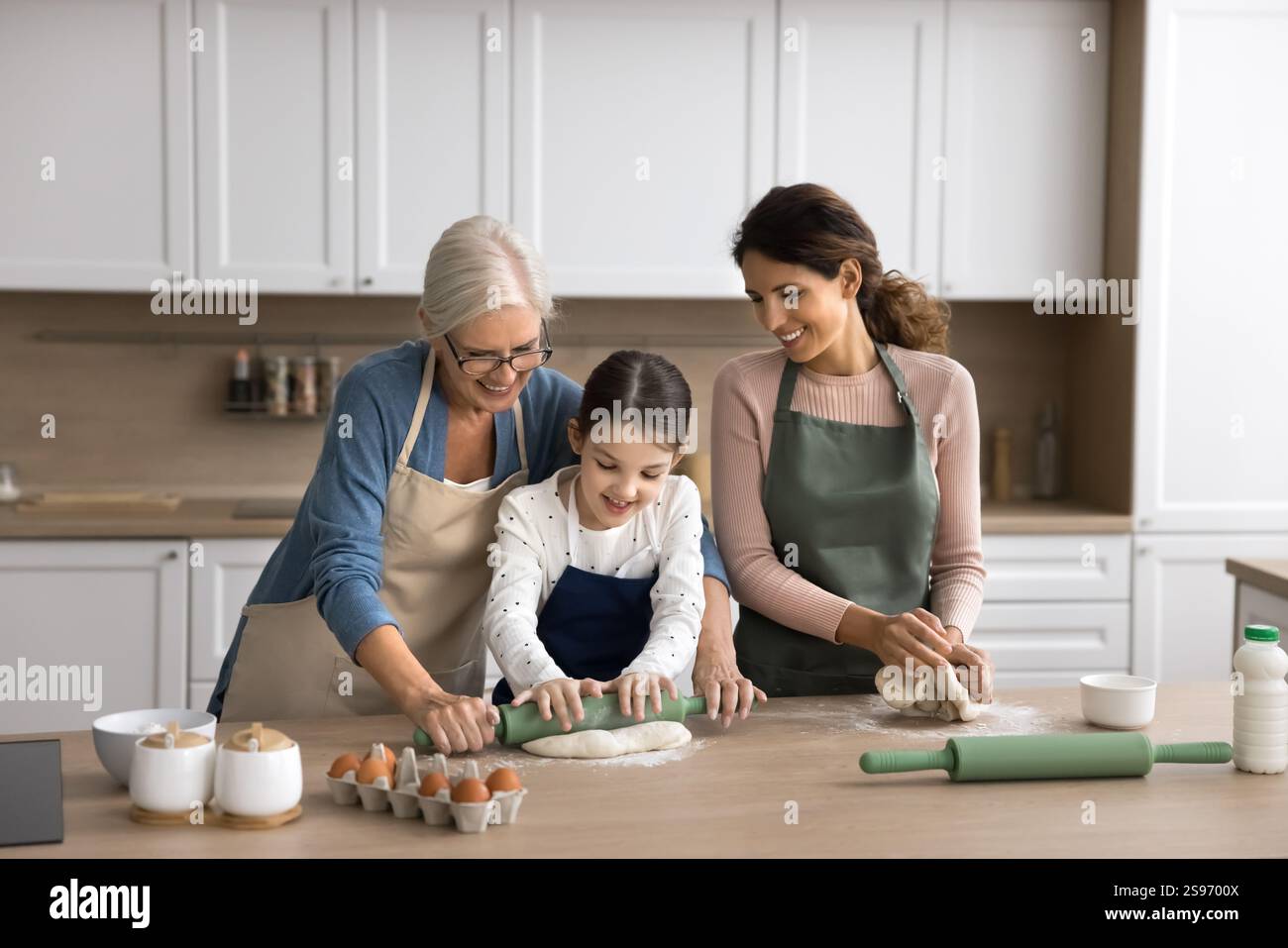Older grandma young mum little girl cook pie at kitchen Stock Photo - Alamy