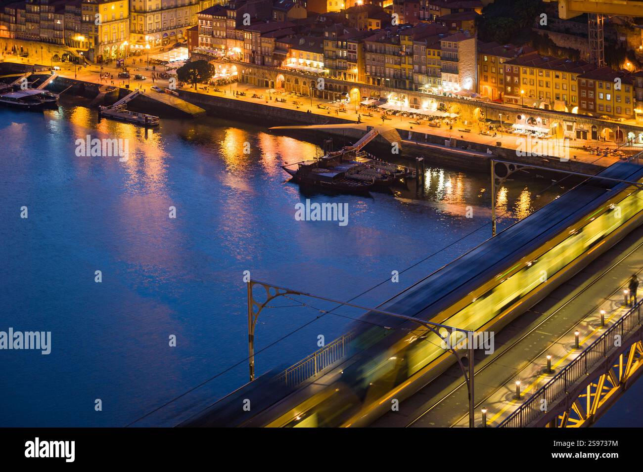 Train Crossing Bridge in Porto with Illuminated Waterfront at Night ...