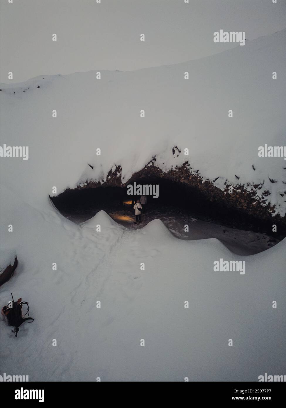Explorers in snowy mountainside cave in the arctic near Longyearbyen ...