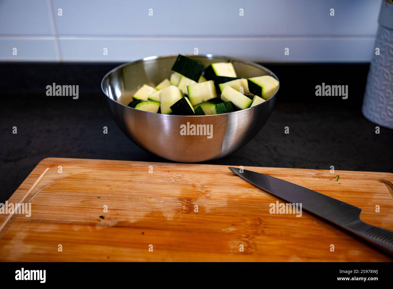 Chopped zucchini in a metal bowl with a knife and cutting board Stock ...