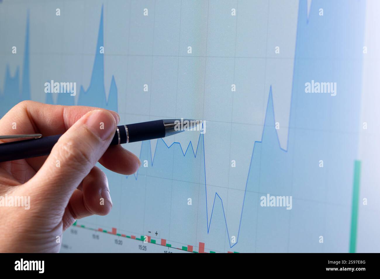 Man hand with pen pointing at financial stock graph on monitor screen ...