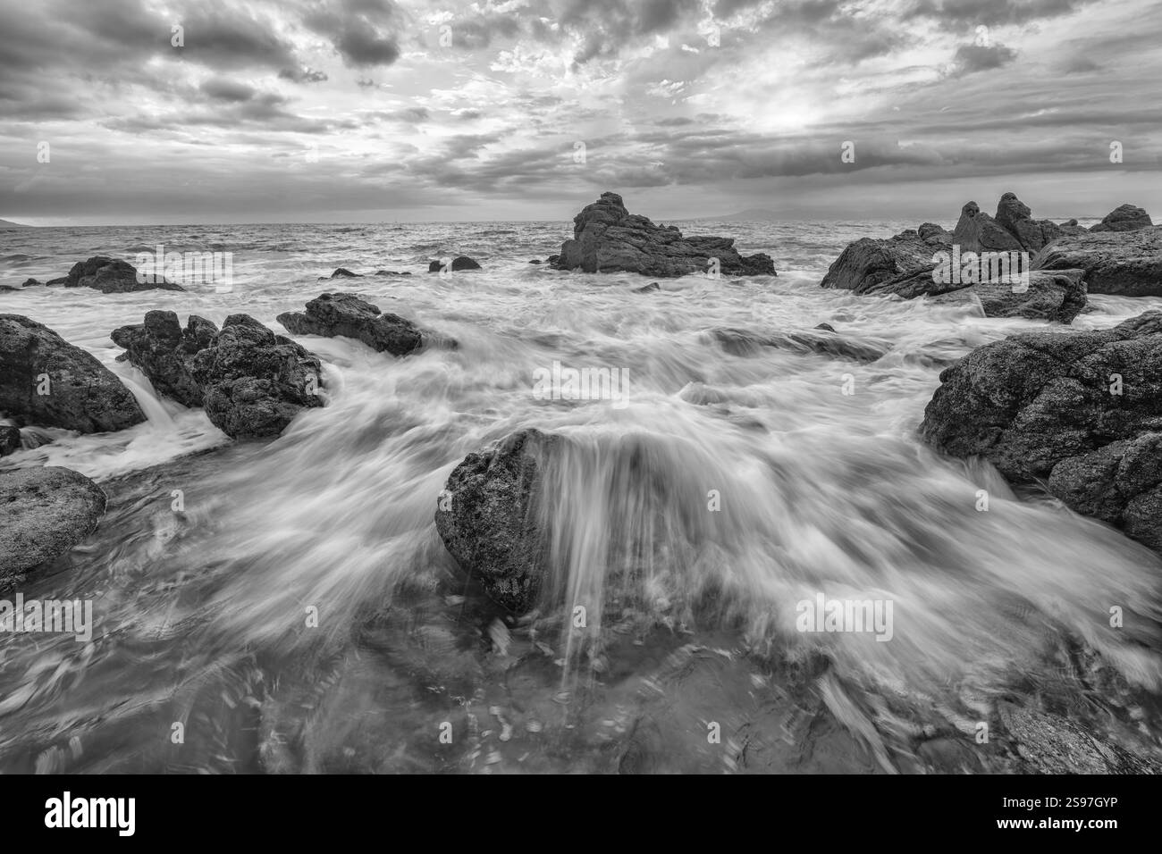 A Wide Angle Closeup Of A Wave Rolling To Shore Flowing Over Sea Rocks ...